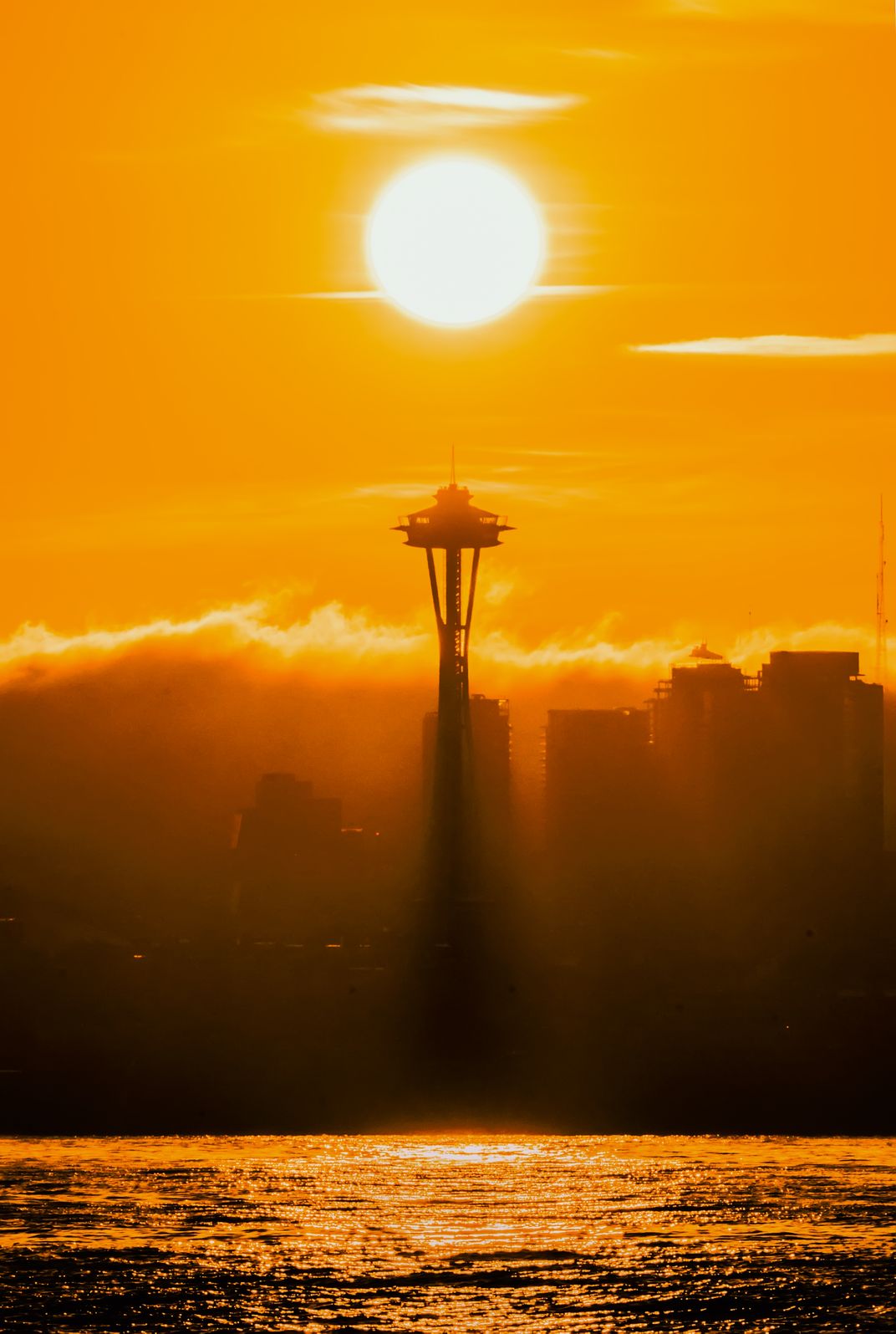Seattle's iconic Space Needle with a setting sun directly above ...