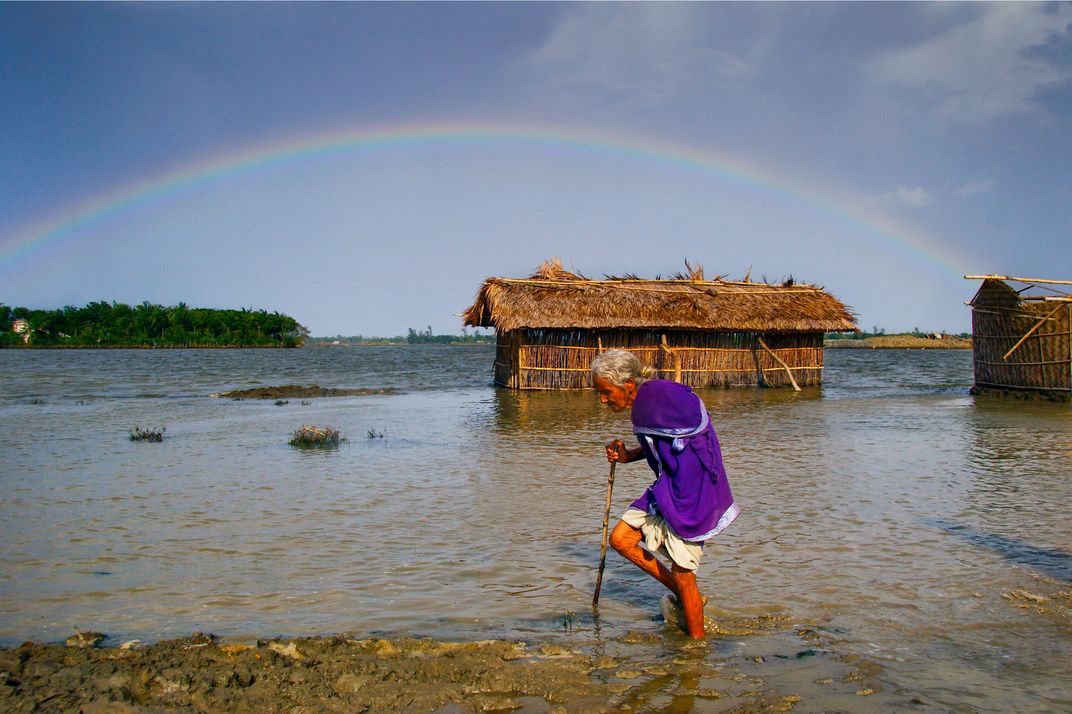 An old woman wades aftermath of a devastating cyclone.The cyclone Aila ...