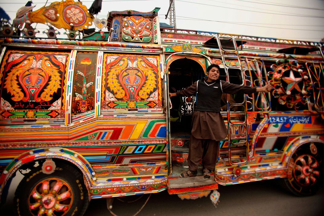 A man enjoying the bus journey while he standing at the door of a ...