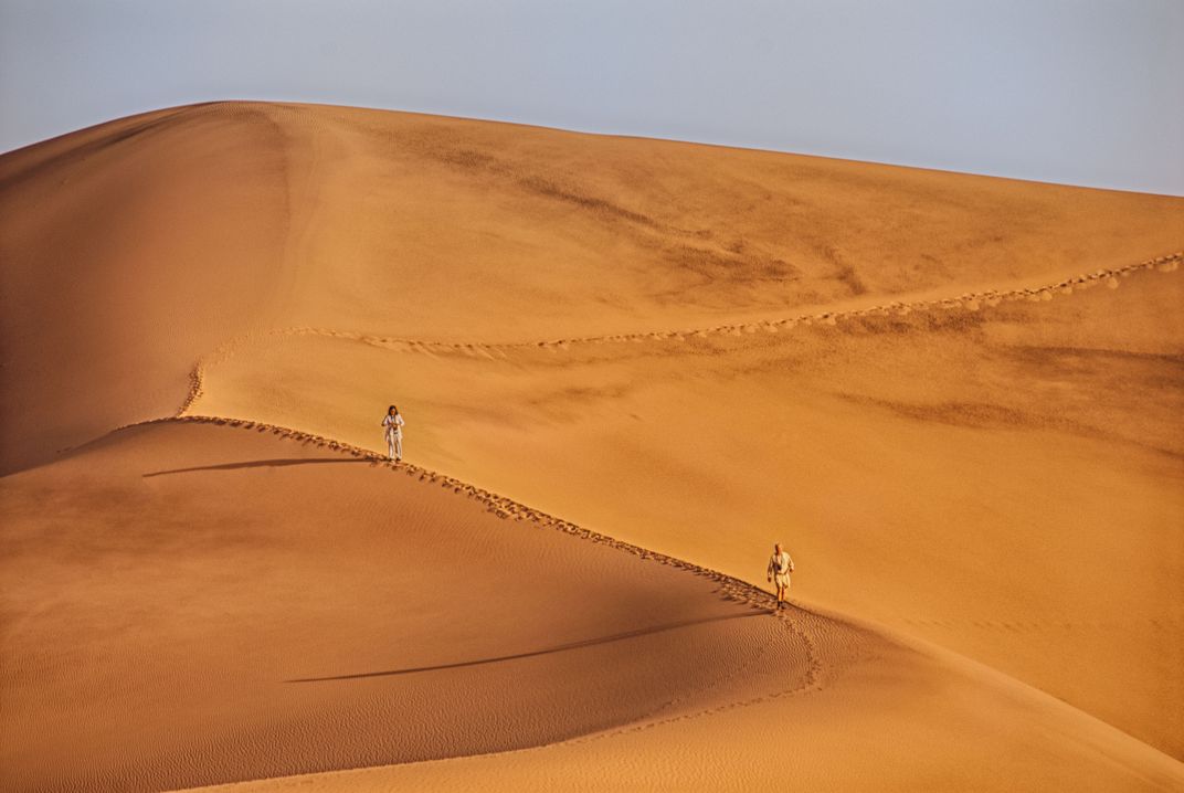 People on ridge of sand dunes in early morning after wind storm the ...