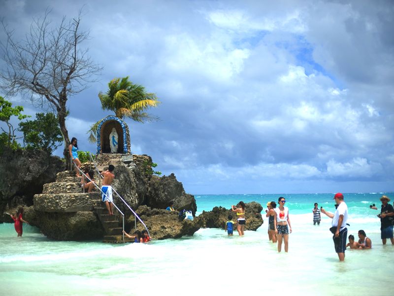 Tourists and locals alike, spend time hanging out next to Boracay Rock ...