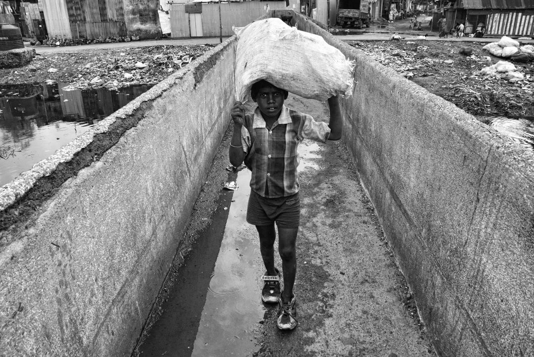Kid carrying wastes from dumpyard and sells it for his living ...