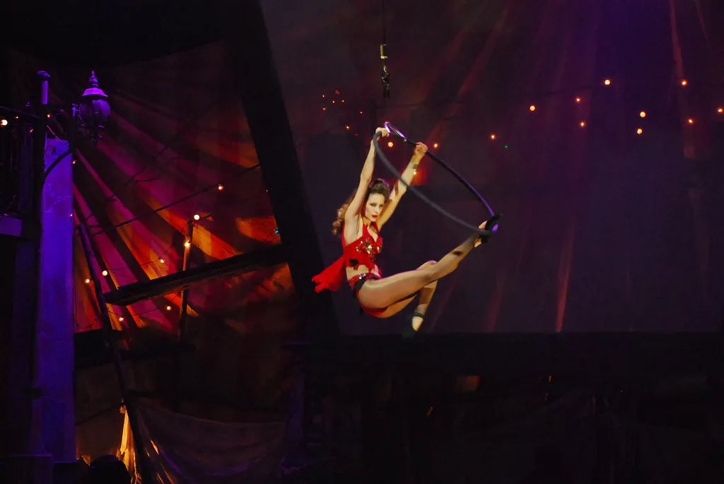 A trapeze artist performs above a stage at a Circus Sideshow in Los ...