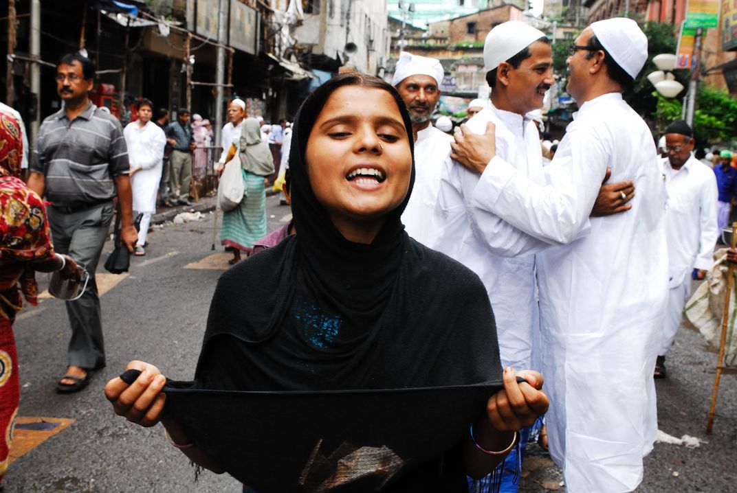 A woman begs for alms after the morning prayer at the Nakhoda mosque on ...