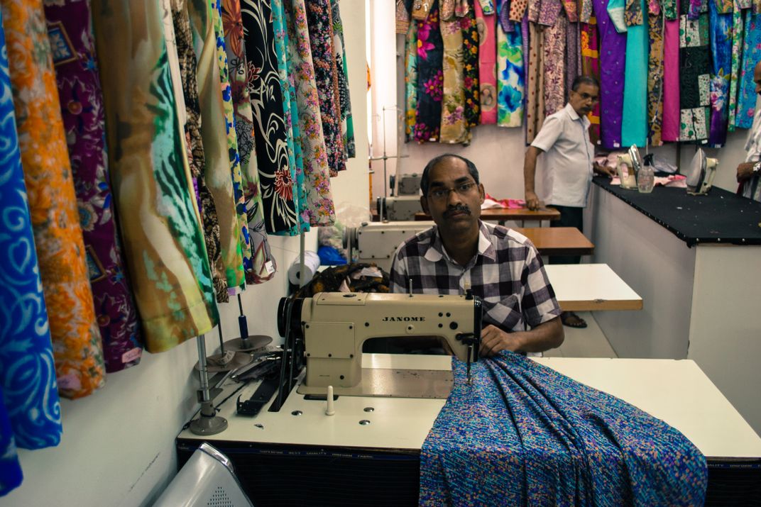 Tailor sewing traditional Emirati clothes that predate the infamous ...