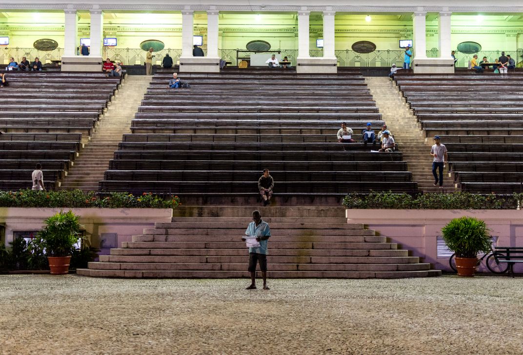 Man checks race odds in Rio De Janeiro race track | Smithsonian Photo ...